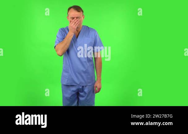 Medical man got a cold, sore throat and head, cough on green screen at ...