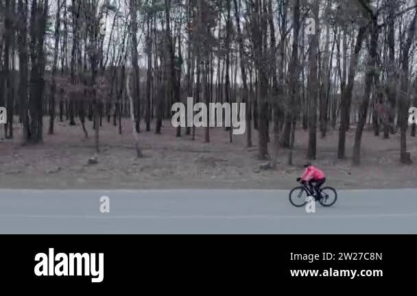 Professional woman cyclist is riding and training on road bike alone ...