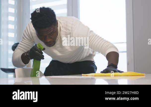 Black man spraying cleaning and disinfecting table surface Stock Video ...