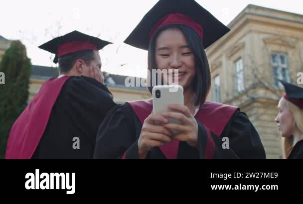 Close up of the Asian graduated female student in a cap and gown ...