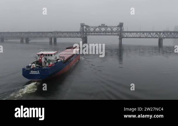 A barge loaded with scrap metal and waste floating on a water surface ...
