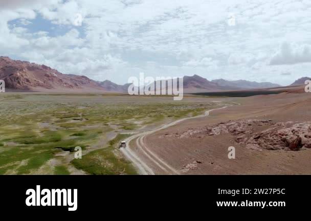 Aerial over off road 4x4 car driving along gravel trail path on arid ...