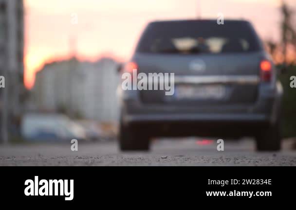 Blurred car with blinking lights on evening city street curb Stock ...