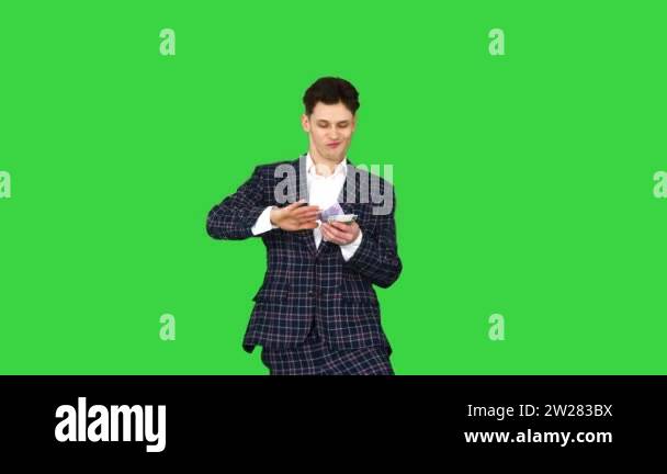 Man in formal suit walking in and throwing money in the air on a Green ...