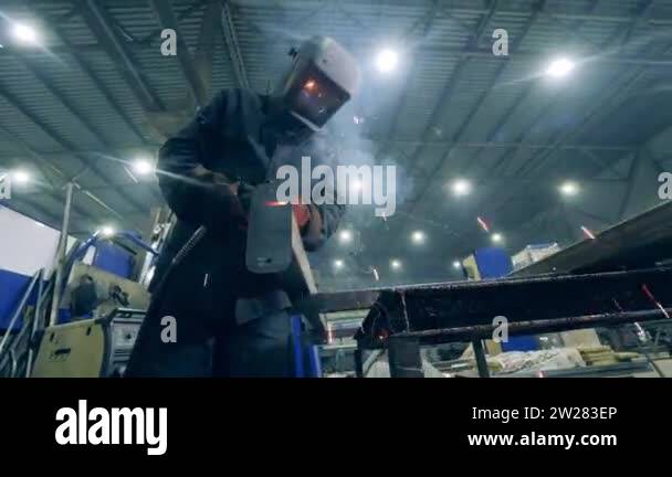 Welding operator is working with iron in a workshop. Professional ...