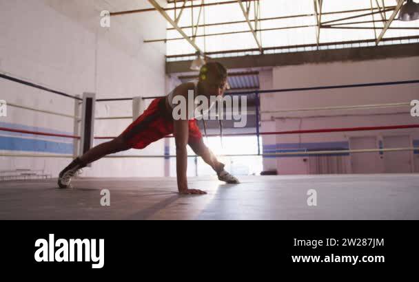Side view of a mixed race female boxer with long plaited hair wearing a ...