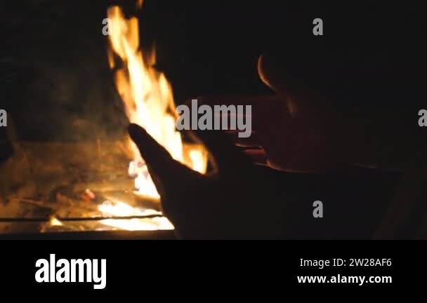 Male tourist warms his arms by a fire from metal brazier against the ...