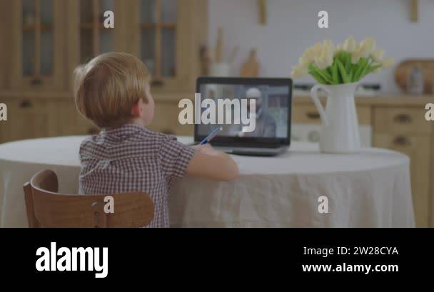 Preschool kid making online school homework with teacher on laptop ...