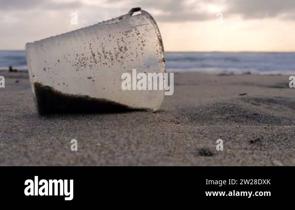 Plastic glass Garbage on sandy sea shore sunset wind motion,polluted ...