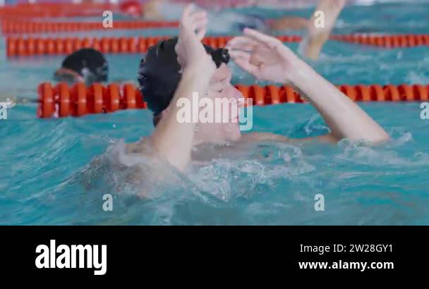 Side view of multi-ethnic group of male swimmers at swimming pool ...