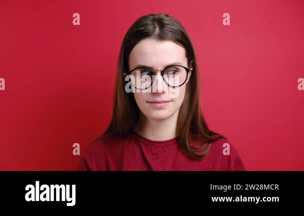 Crazy comic female in glasses makes funny face, crosses eyes, plays ...