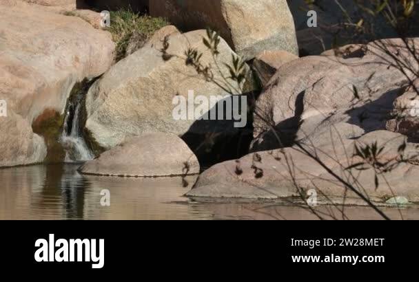 Detail of small fall and lake in rocky background. Out of focus ...