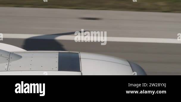 Plane taking off the runway with the shadow of the wing, view from the ...