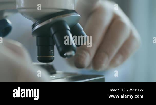 Close up of microscope oculars being directed at a sample on a piece of ...