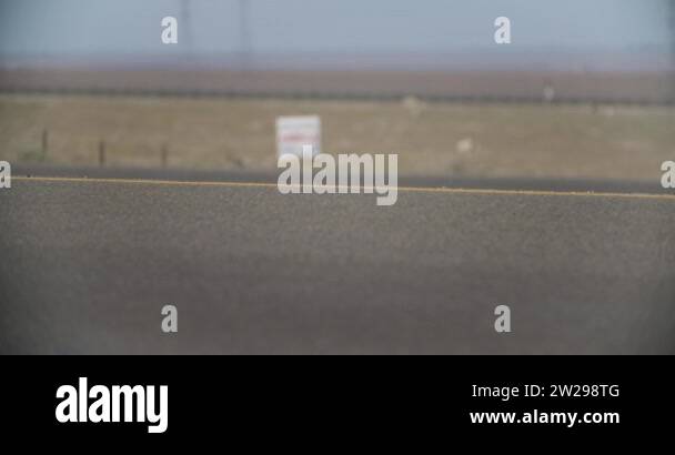MAGA Sign Freeway Rack Focus. Across a busy highway, a tiny sign reads ...