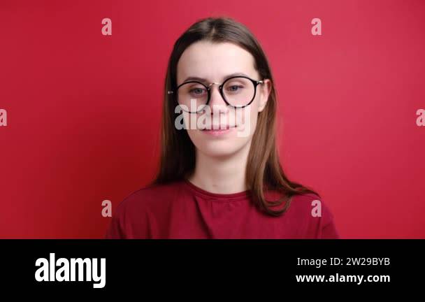 Cute young girl in glasses makes funny face, crosses eyes and sticks ...
