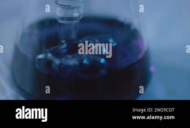 Bubbles coming out of a graduated pipette in a conical flask, during an ...