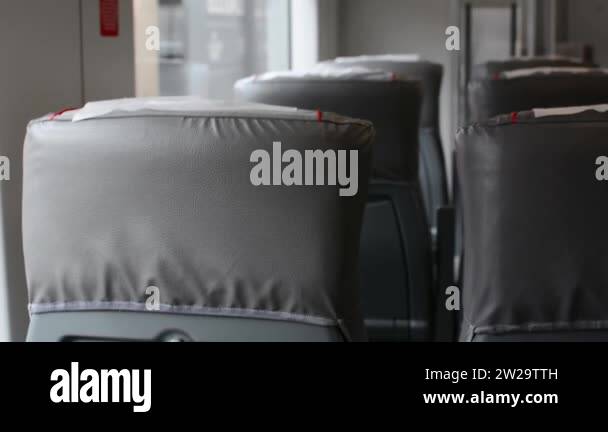 Back view between the gray train seats with folding tables. Blurred ...
