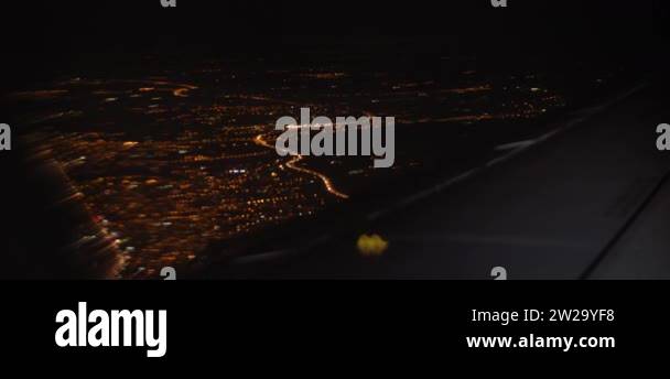Aerial view of city from airplane window at night. Plane flying above ...