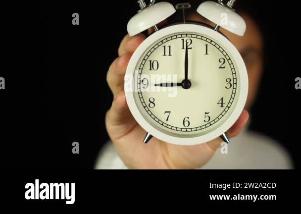 9 oclock. Human hand holding alarm clock that showing nine oclock and ...