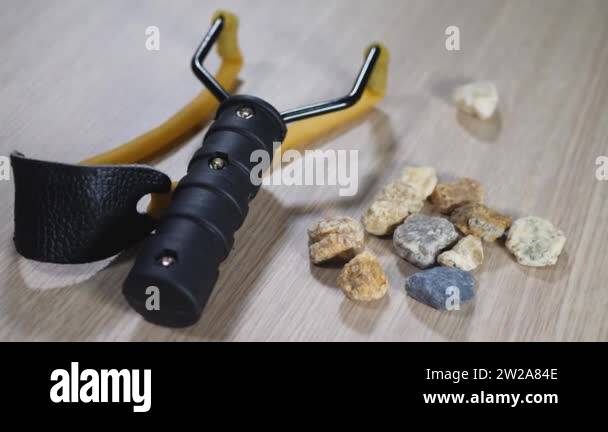 Slingshot small hand-powered projectile weapon with stone and rock ...