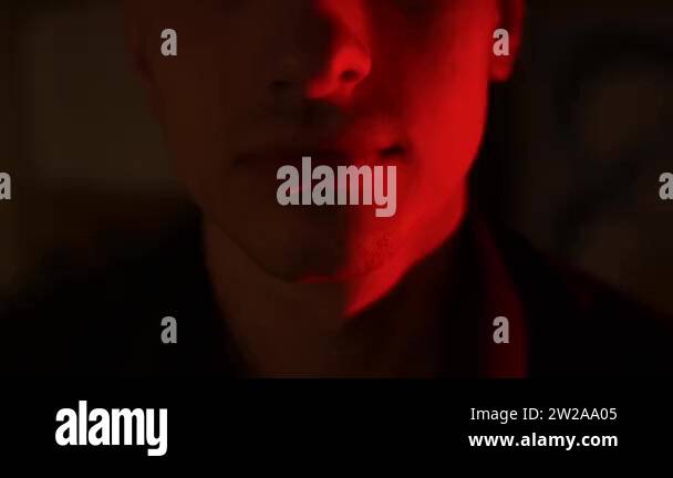 A man takes pills. The guy swallows pills, drugs in a red light. Party ...