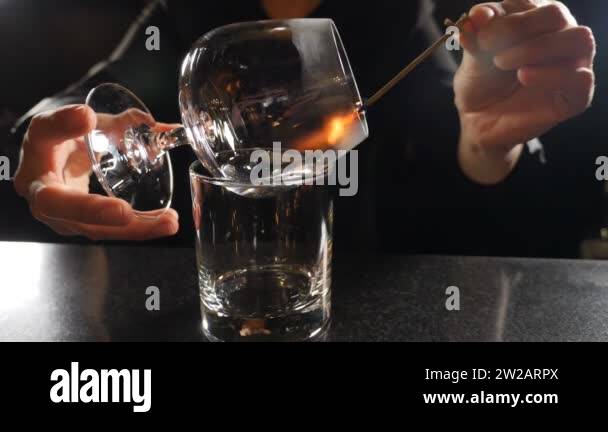 Slow motion cocktiail video of barman setting fire on alcohol drink ...