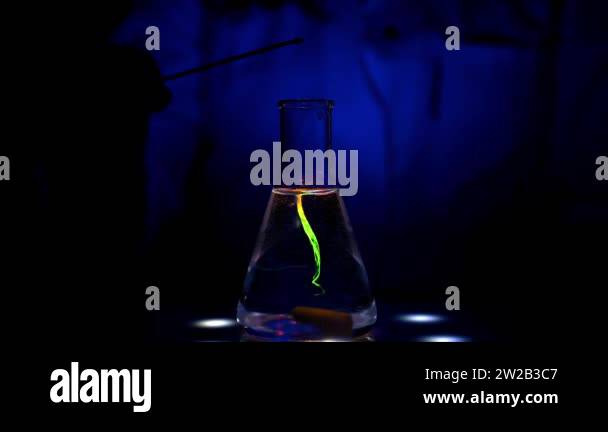 A laboratory scientist is mixing different color solution on a magnetic ...