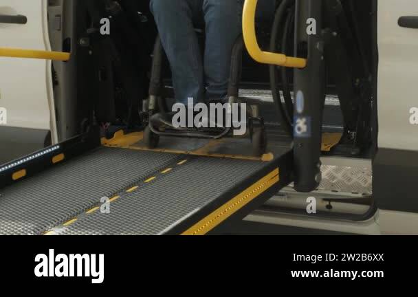 A man in a wheelchair on a lift of a vehicle for people with ...