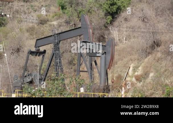 Industrial urban landscape. La Brea Inglewood in Los Angeles. Well pump jack operating behind ...