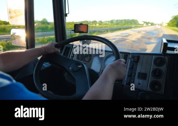 Unrecognizable lorry driver holding hands on steering wheel and ...
