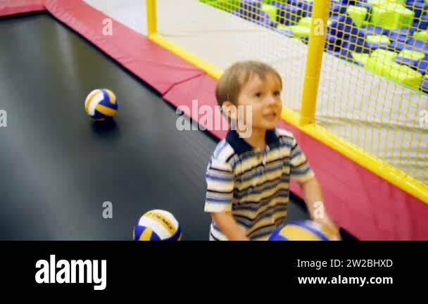 4k video of little boy throwing balls in basketball ring on trampoline ...