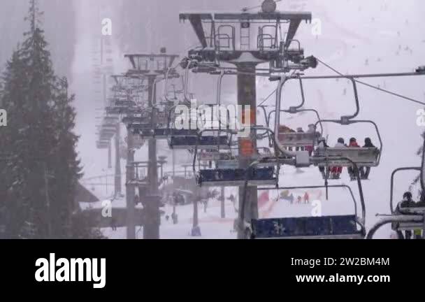Ski Lift on Ski Resort. Skiers Climb on a Ski Chair Elevator up to Ski ...