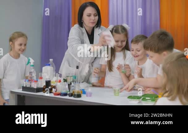 Chemical experiments for children. Woman pours a green substance into a ...