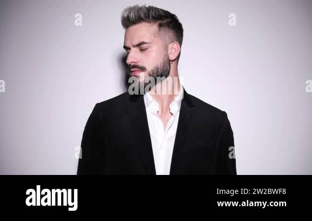 elegant young man holding hand to chin, sensually touching lips ...