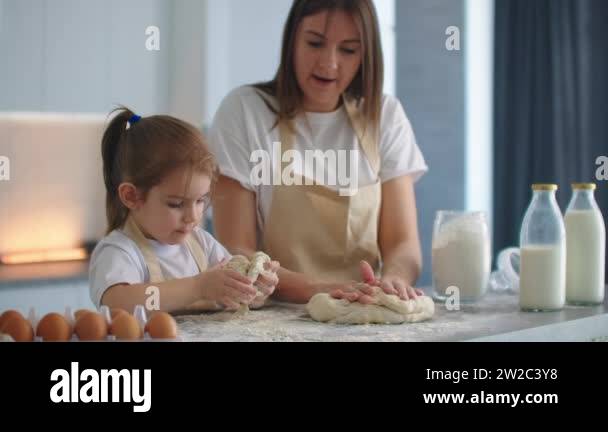 Mother and daughter cooking with dough mold in kitchen. Mother and ...
