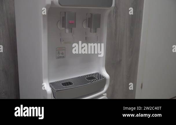 finger press valve on office water filter dispenser Purifier. Water is ...