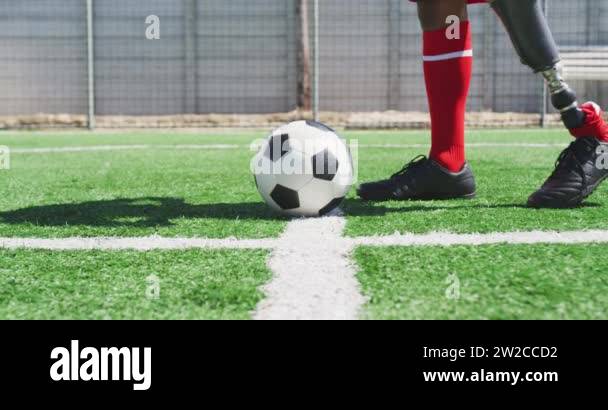 Side view low section of a mixed race male football player with a ...