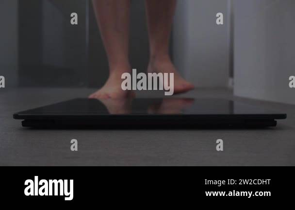 Woman measuring her weight on a weighing scale Stock Videos & Footage ...