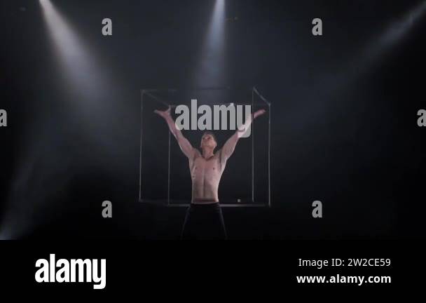 circus male muscular performer making tricks with juggling cube props ...