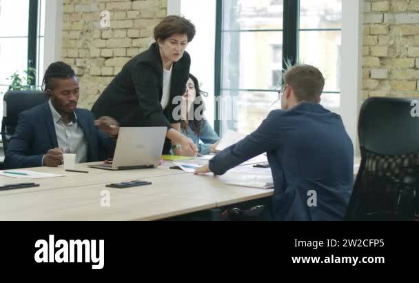 Successful business consultant analyzing diagrams with multiethnic team ...