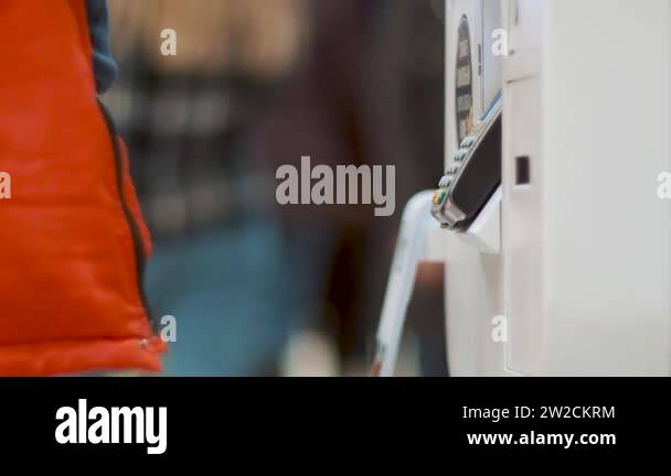 Person attach smartphone to a self-service terminal. Guy makes a purchase online using a NFC ...