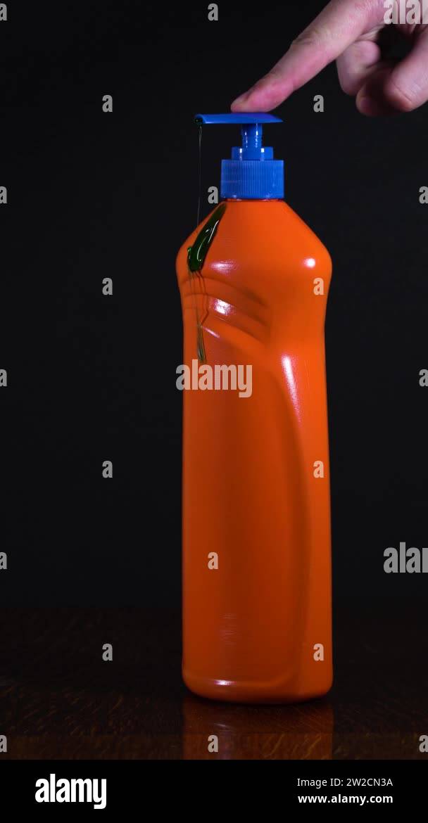 Orange bottle of detergent. Bottle without labels and name. Hand ...