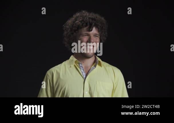 Long haired young guy smile in a silly way and wiggles isolated against ...