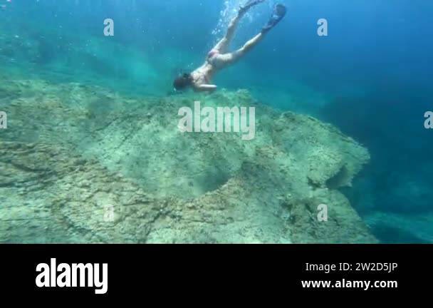 Underwater View Of Girl In Bikini Snorkeling In Crystal Clear Sea Water