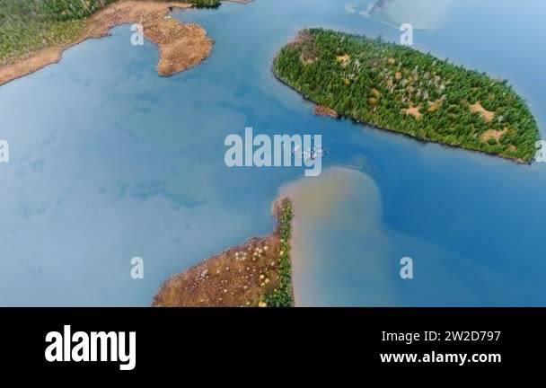 Vivid footage of the lake and small islands with dense forest shot by a ...