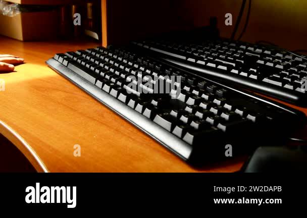 Close-up of a black keyboard on a wooden table, a small child's hands ...