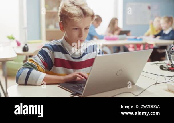 Smart Schoolboy Uses Laptop to Program Software for Robotics Engineering Class. Elementary ...