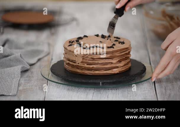 Step by step. Pastry chef making chocolate layer cake with prune ...