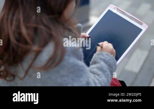 Concentrated little girl drawing stick figures on a tablet Stock Video ...